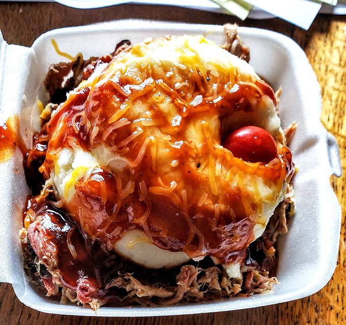 The pulled pork sundae defies convention and gravity – layers of smoky meat and savory sides stacked like the world's most delicious geological formation.