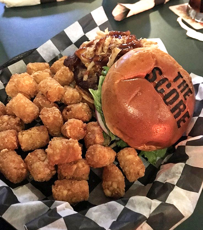 The Rodeo BBQ Burger arrives branded with "THE SCORE" on its bun &ndash; a delicious billboard that pairs perfectly with golden tater tots.