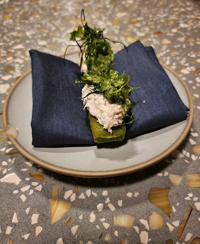 Delicate smoked whitefish nestled on a vibrant green base, served with the kind of artistic presentation that makes you pause before diving in.