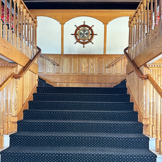 The grand staircase welcomes guests aboard, its polished wood and nautical details setting the stage for an evening of mystery.