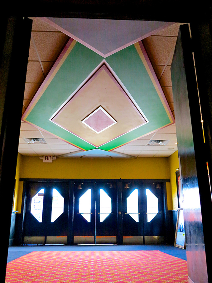 The lobby's geometric ceiling design draws eyes upward, a colorful prelude to the main attraction that awaits beyond.