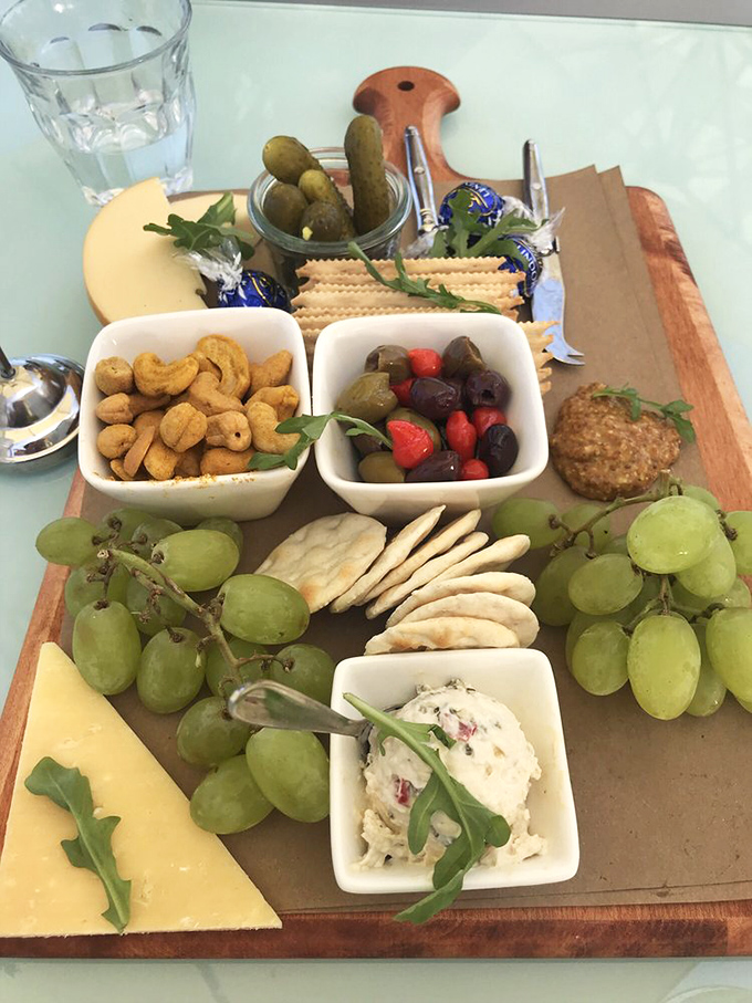 Grazing board bliss: A meticulously arranged vegetarian cheese board featuring local produce, artisanal crackers, and seasonal fruits that complement the estate's wines.