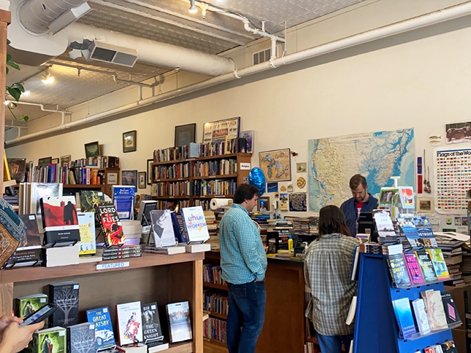 Book lovers engage in the ancient ritual of recommendation and discovery, their expressions revealing the thrill of literary connection.