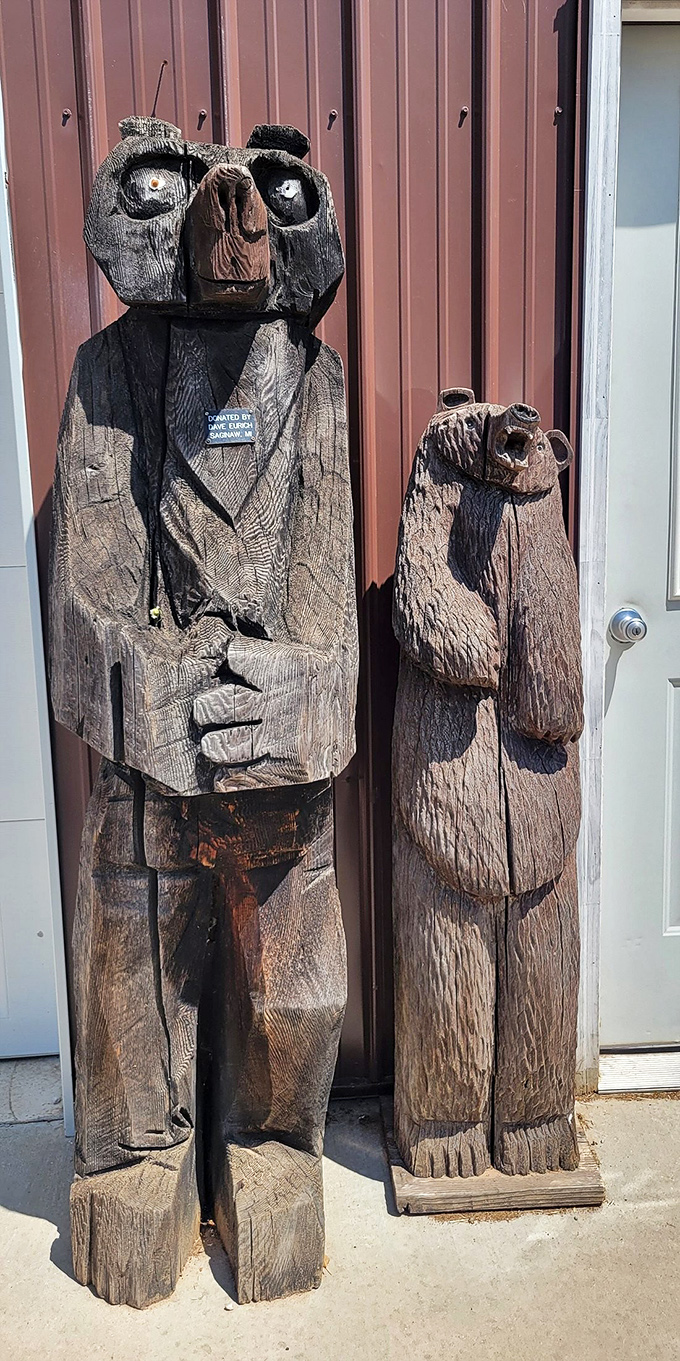 Wooden bear sentinels guard the entrance, carved with expressions ranging from "welcome" to "did you bring snacks?"
