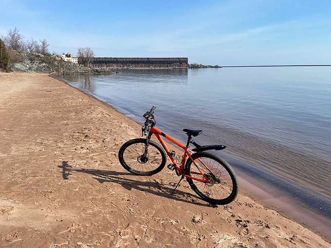 A lone bike rests on Lake Superior's shore, where the world's largest freshwater sea stretches to the horizon like nature's infinity pool.
