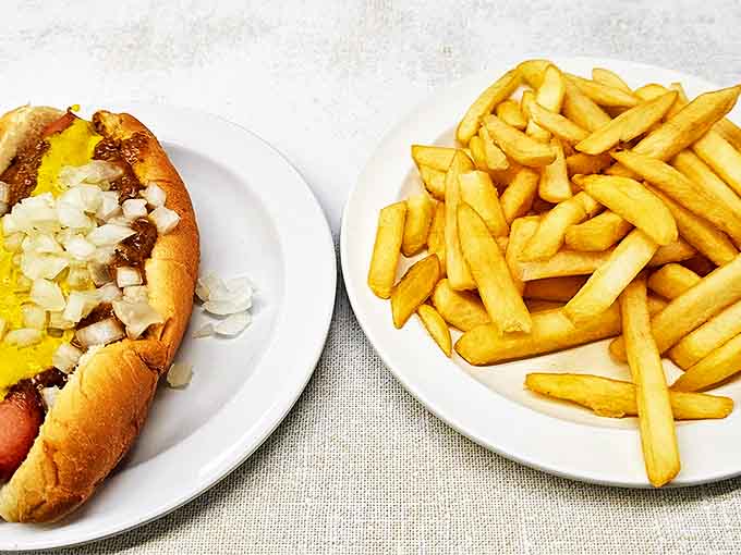 The classic Coney Island hot dog with fries represents Detroit's culinary soul &ndash; a natural-casing dog topped with chili, mustard, and onions that snap with each delicious bite.
