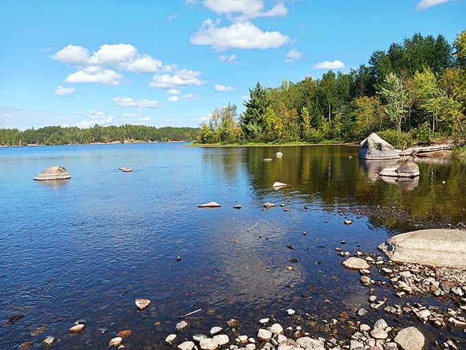 Tranquil waters downstream &ndash; after the dramatic plunge, the Kawishiwi River settles into this serene lake, reflecting Minnesota's pristine skies.