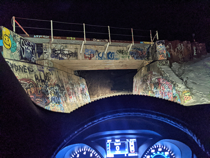 Headlights illuminate the passage at night, creating an eerie glow that highlights the most recent additions to this ever-changing gallery.