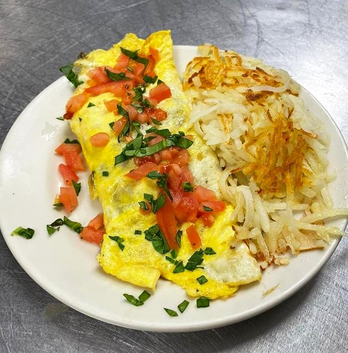 This isn't just any omelet &ndash; it's a yellow blanket of perfection cradling fresh ingredients, with hash browns that achieve the mythical crispy-outside, tender-inside balance.