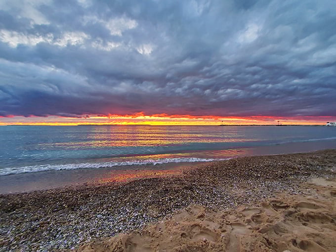 Mother Nature's nightly masterpiece paints the sky in fiery hues, turning Lake Michigan into a mirror that doubles the spectacular show.