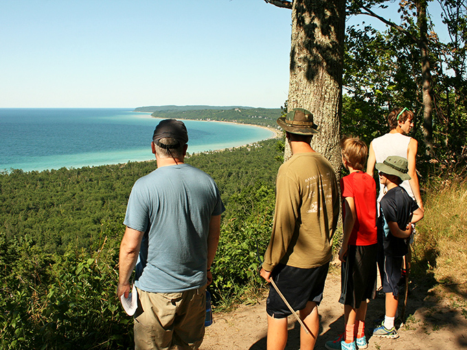Hikers pausing at the overlook, experiencing that universal moment when smartphones suddenly seem inadequate for capturing such vastness.