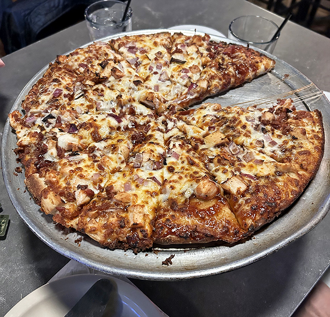 BBQ Chicken pizza arrives with a symphony of flavors &ndash; tangy sauce, tender chicken, and red onions creating harmony on a perfect crust.