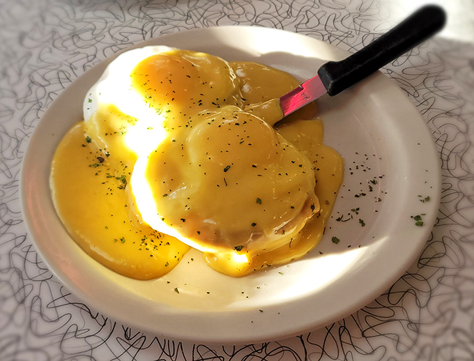 Poached eggs perched like delicate clouds, ready to release their golden treasure onto Canadian bacon and English muffins.