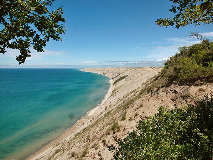 Towering sand meets turquoise waters in a geological marvel that feels more Caribbean than Michigan.