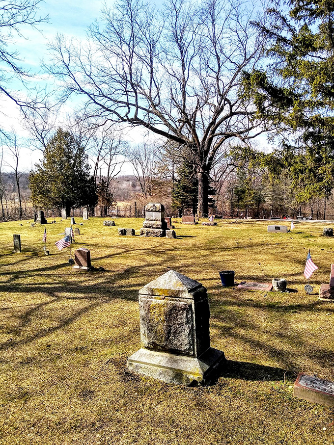 Sunlight transforms the cemetery into a peaceful historical site, but locals say the witch only emerges when shadows grow long.