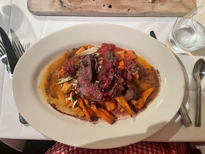 The hanger steak arrives like a work of art &ndash; perfectly cooked beef nestled among root vegetables in a rich jus.