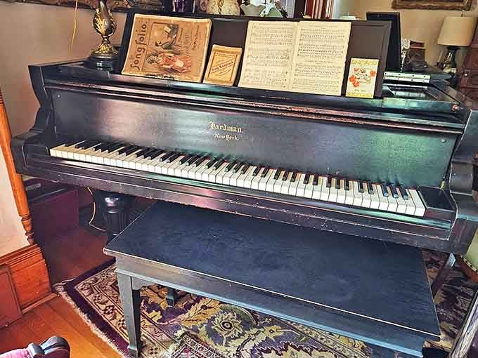 The Hardman grand piano waits silently for phantom fingers to bring Chopin or Liszt back to life in the parlor.