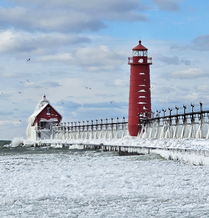 Winter transforms the Grand Haven lighthouse into an ice sculpture, with frozen waves creating a surreal landscape worthy of fantasy films.