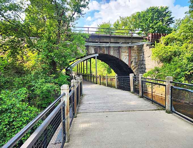 Mill Creek Park's wooden boardwalk leads under a magnificent stone railway bridge, creating the perfect backdrop for family photos or quiet contemplation.