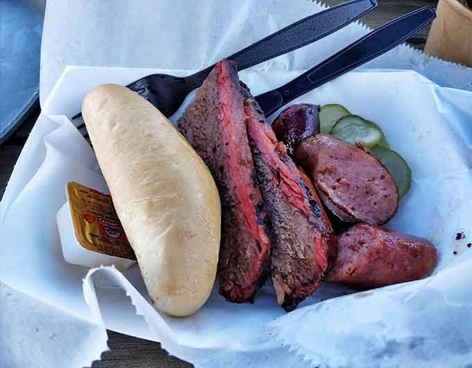 The carnivore's dream plate: slices of brisket alongside snappy sausage, with pickles providing that essential acidic balance.