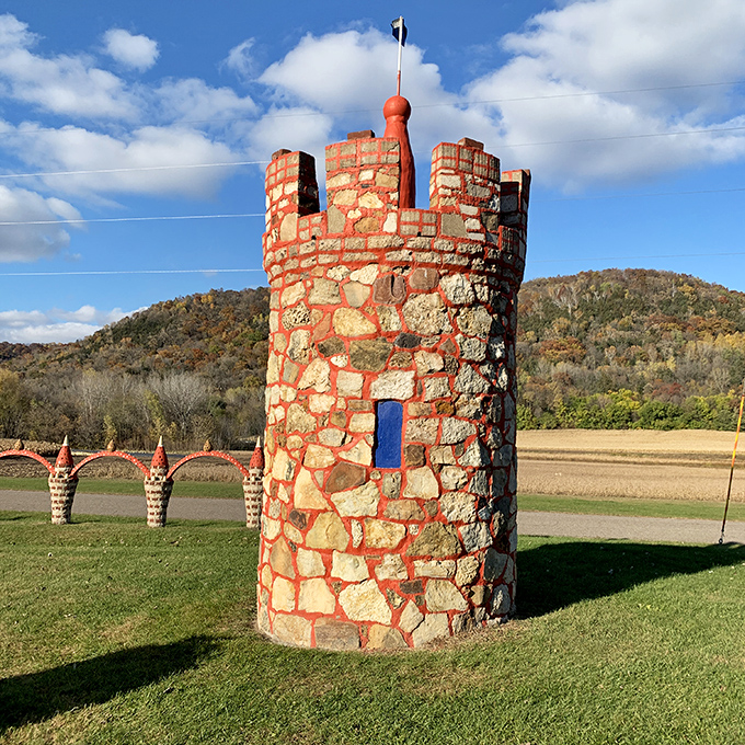 This stone tower, complete with blue door and red-topped turret, looks like it escaped from a storybook castle to vacation in the countryside.