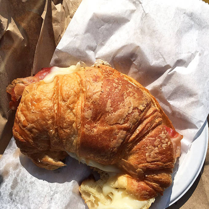 Breakfast sandwich perfection achieved through the marriage of crispy bacon, melty cheese, and that impossibly flaky croissant that shatters at first bite.