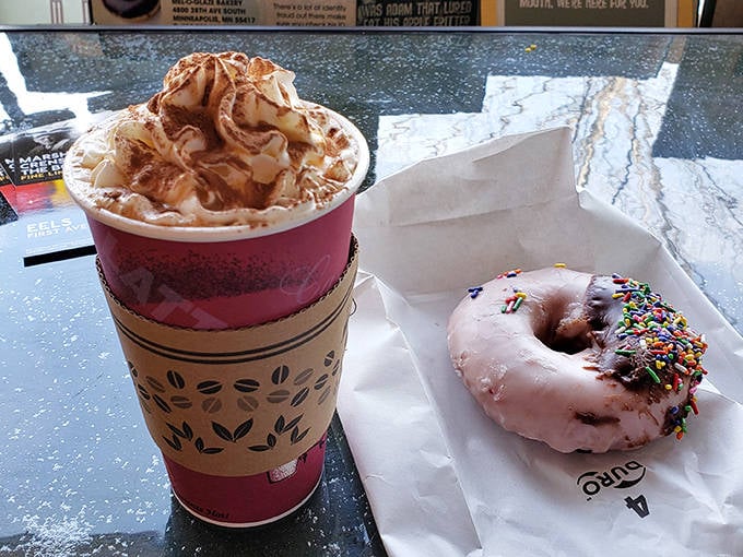 The ultimate power couple: a mountain of whipped cream atop steaming hot chocolate, paired with a donut that's dressed for the occasion.
