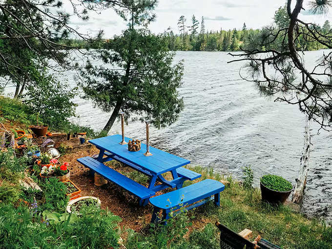 This bright blue picnic table isn't just outdoor furniture, it's front-row seating to nature's greatest performance: Minnesota lakeside living.