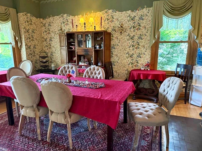 Elegant tufted chairs surround a crimson-draped table, creating the perfect setting for both breakfast and Victorian gossip.