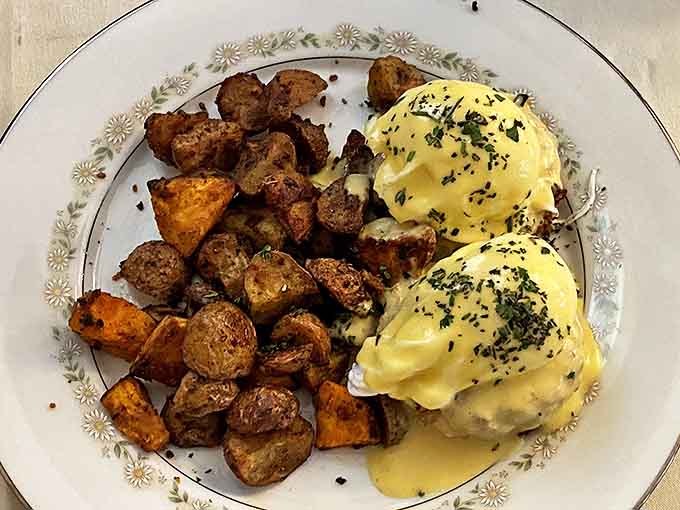 Benedict done brilliantly &ndash; golden hollandaise cascading over perfectly poached eggs, accompanied by seasoned potatoes that steal the spotlight.