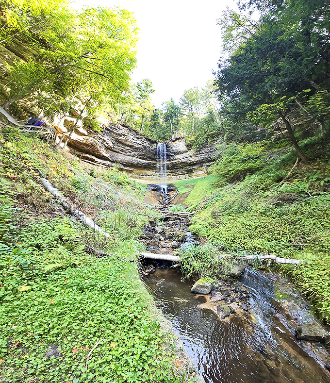 Summer sunshine illuminates the broad cascade of Wagner Falls, creating a refreshing oasis during Michigan's warmer months.