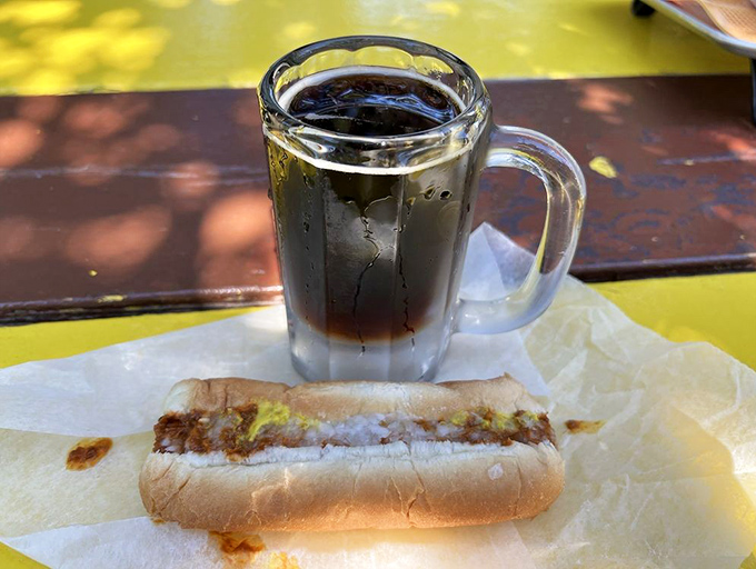 The perfect Michigan summer pairing &ndash; a classic dog and a mug of house-made root beer, enjoyed at a sun-dappled picnic table.