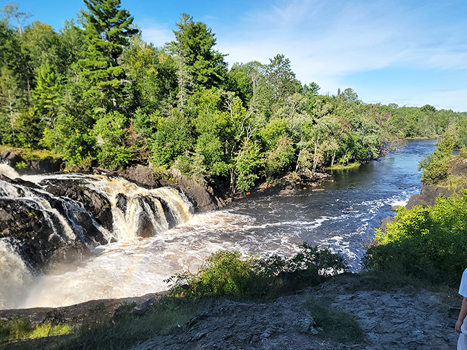 The river's journey continues &ndash; water that tumbled over the falls moments ago now meanders peacefully between pine-studded banks.