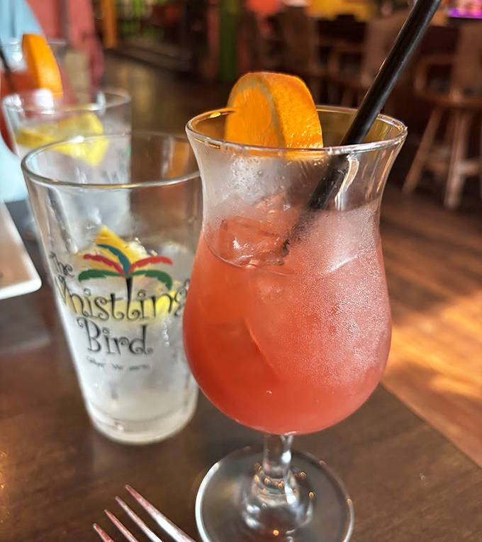 This isn't just a rum punch—it's liquid sunshine in a glass, complete with a fresh orange slice winking at you.