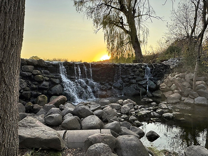 Sunset transforms the waterfall into liquid gold, proving that Mother Nature was the original Instagram influencer.