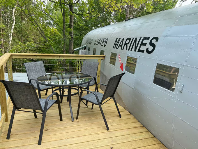 A wooden deck wraps around the aircraft, creating perfect perches for morning coffee with United States Marines insignia visible.
