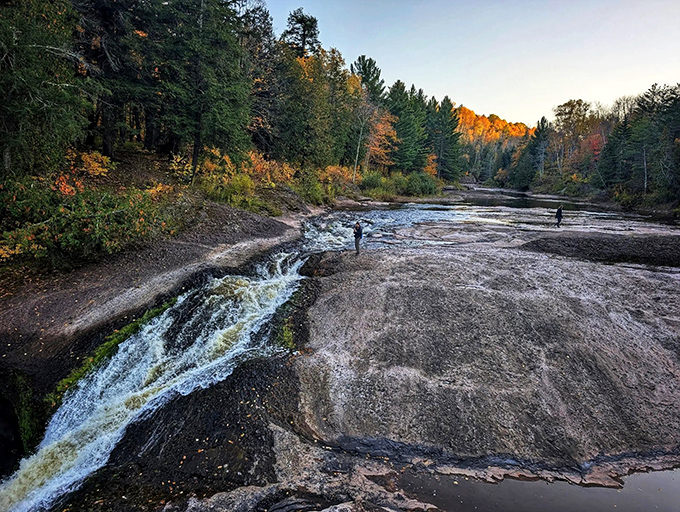 Autumn transforms the waterfall vista into a painter's palette of golden hues, where rushing waters cut through fall foliage like nature's own contrast filter.