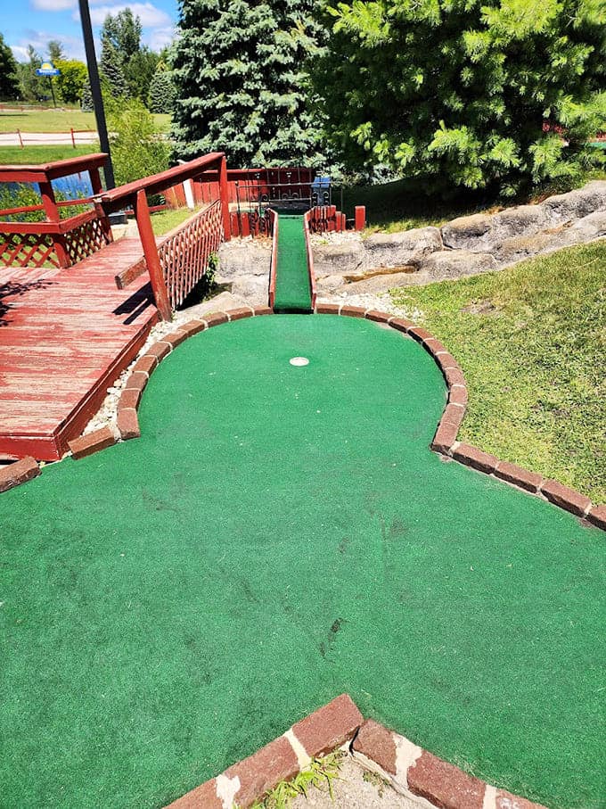 The mini golf course winds through landscaped terrain where your putting skills meet creative obstacles and occasionally, your ball finds water.