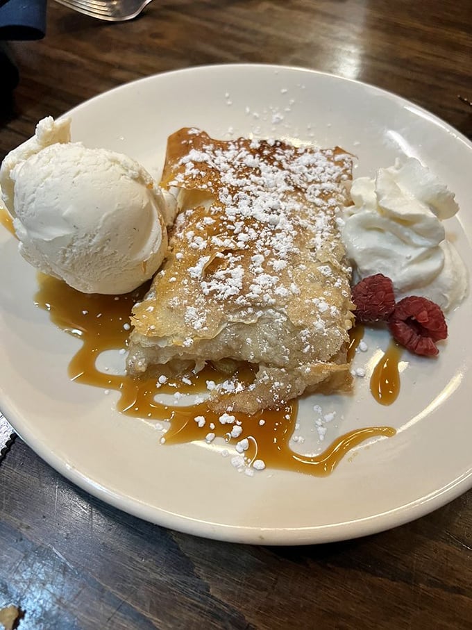 Apple Strudel: Flaky pastry embracing warm cinnamon-spiced apples, crowned with vanilla ice cream and caramel – dessert doesn't get more classically comforting than this.