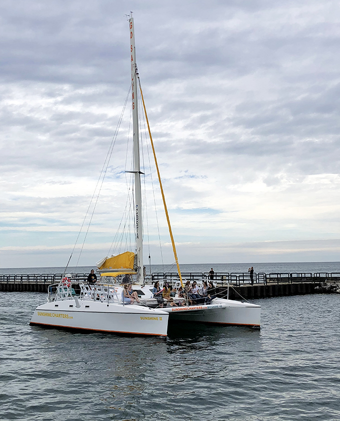 Sailing dreams come true: a catamaran glides past the Charlevoix South Pier, offering passengers front-row seats to nature's grandeur.