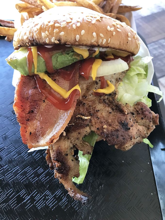 A big chicken burger arrives looking like the star of the meal, its crispy skin and bold seasoning promising a flavor explosion in every bite.