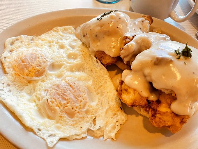 Chicken and Biscuits: Southern comfort meets Wisconsin hospitality &ndash; golden fried chicken smothered in creamy gravy alongside perfectly cooked eggs.