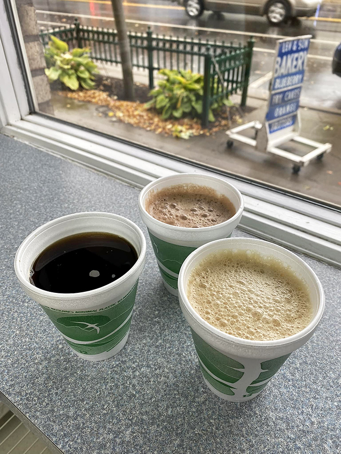 Three cups of coffee in green-sleeved glory, because even the beverages here understand the importance of looking good together.