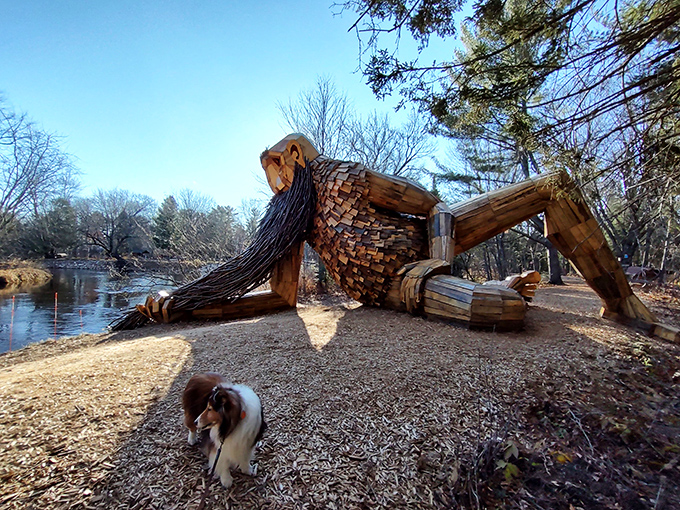 A curious canine investigates Michigan's famous wooden resident, adding an adorable sense of scale to the massive sculpture.