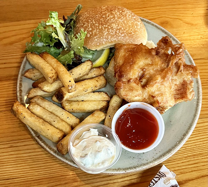 Golden-battered fish extends well beyond its bun in this sandwich masterpiece, accompanied by hand-cut fries that deserve their own fan club.