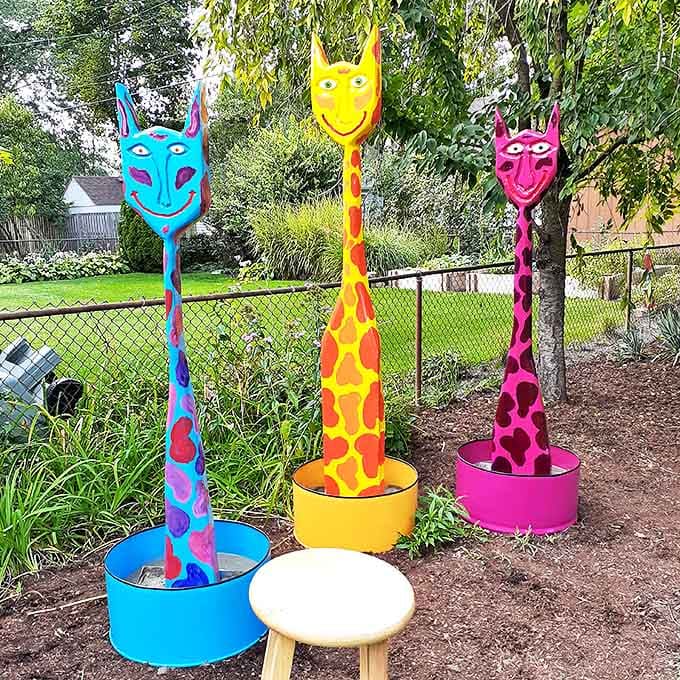 Three spotted creatures stand tall in their vibrant containers, like exotic plants that grew into something far more magical.