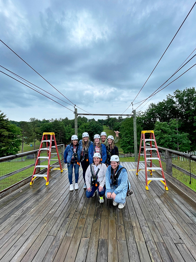 Group Zipline Portrait: The universal "we survived" pose. Nothing bonds strangers faster than collectively questioning life choices while strapped in harnesses.