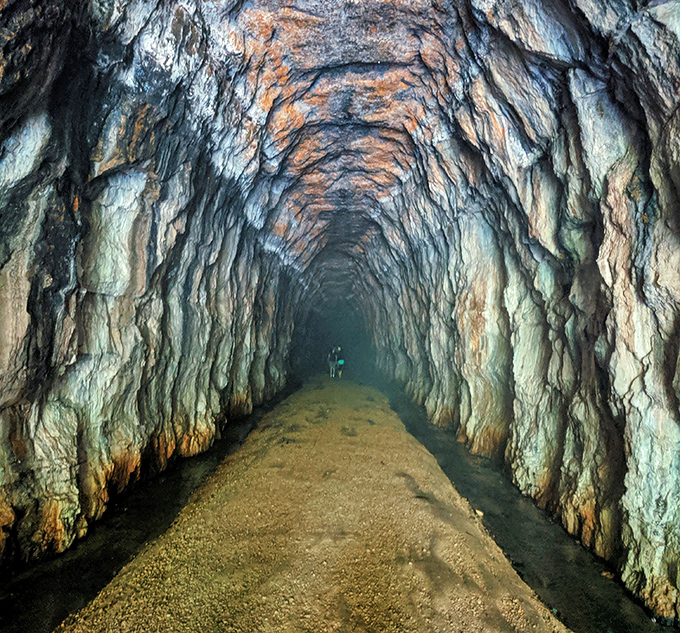 Inside the tunnel, limestone walls glisten with moisture, creating an otherworldly passage that feels like stepping into another era.