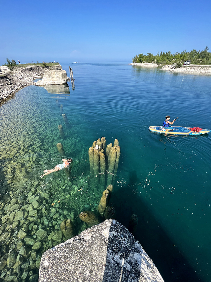 Adventurers explore the crystal waters by paddle and swim, discovering underwater treasures hidden beneath the surface.