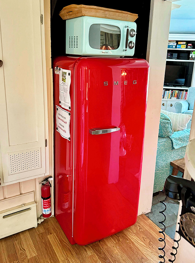 That cherry-red SMEG isn't just a refrigerator, it's a pop of playful color that says "even appliances can spark joy!"